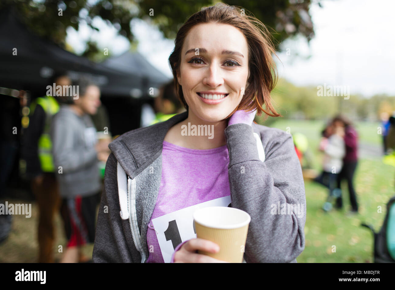 Portrait smiling female marathon runner drinking water in park Stock ...