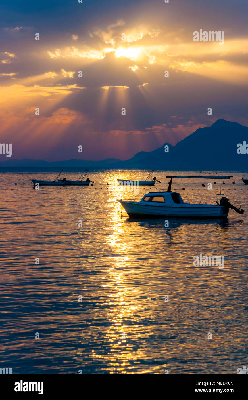 Sunset sun beams penetrating through the clouds on Adriatic sea coast ...