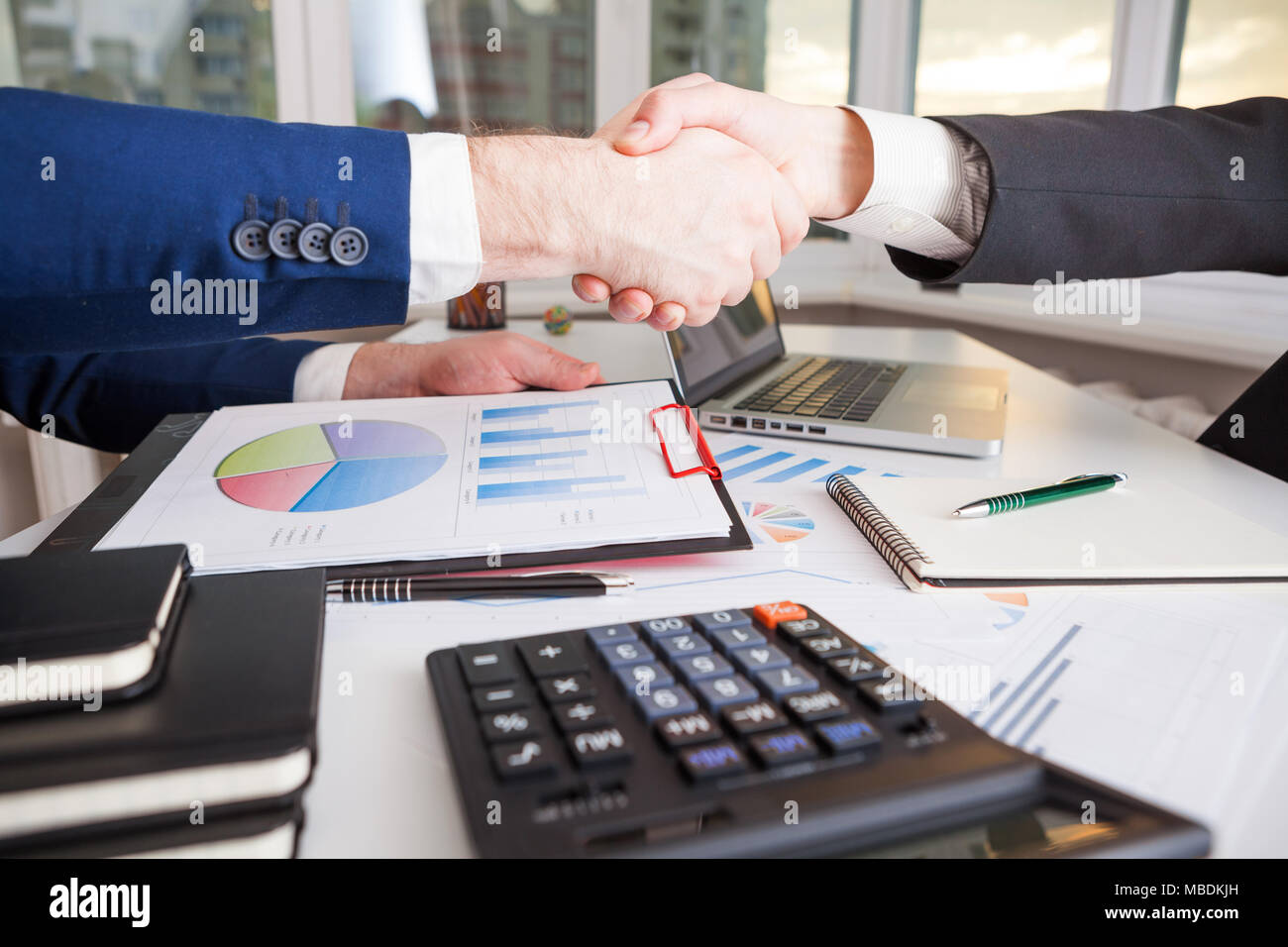 Business people shaking hands finishing up a meeting handshake ...