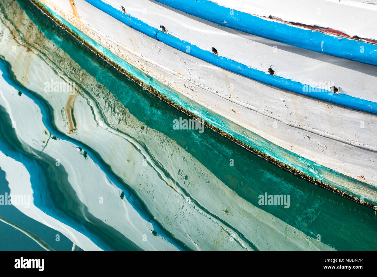 Colorful, vivid- blue, turquoise and white side boat lines reflected in ...