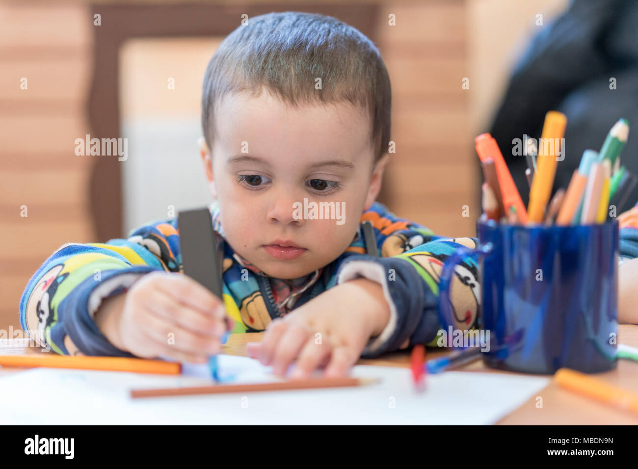 Cute little boy writing something in notebook Stock Photo - Alamy