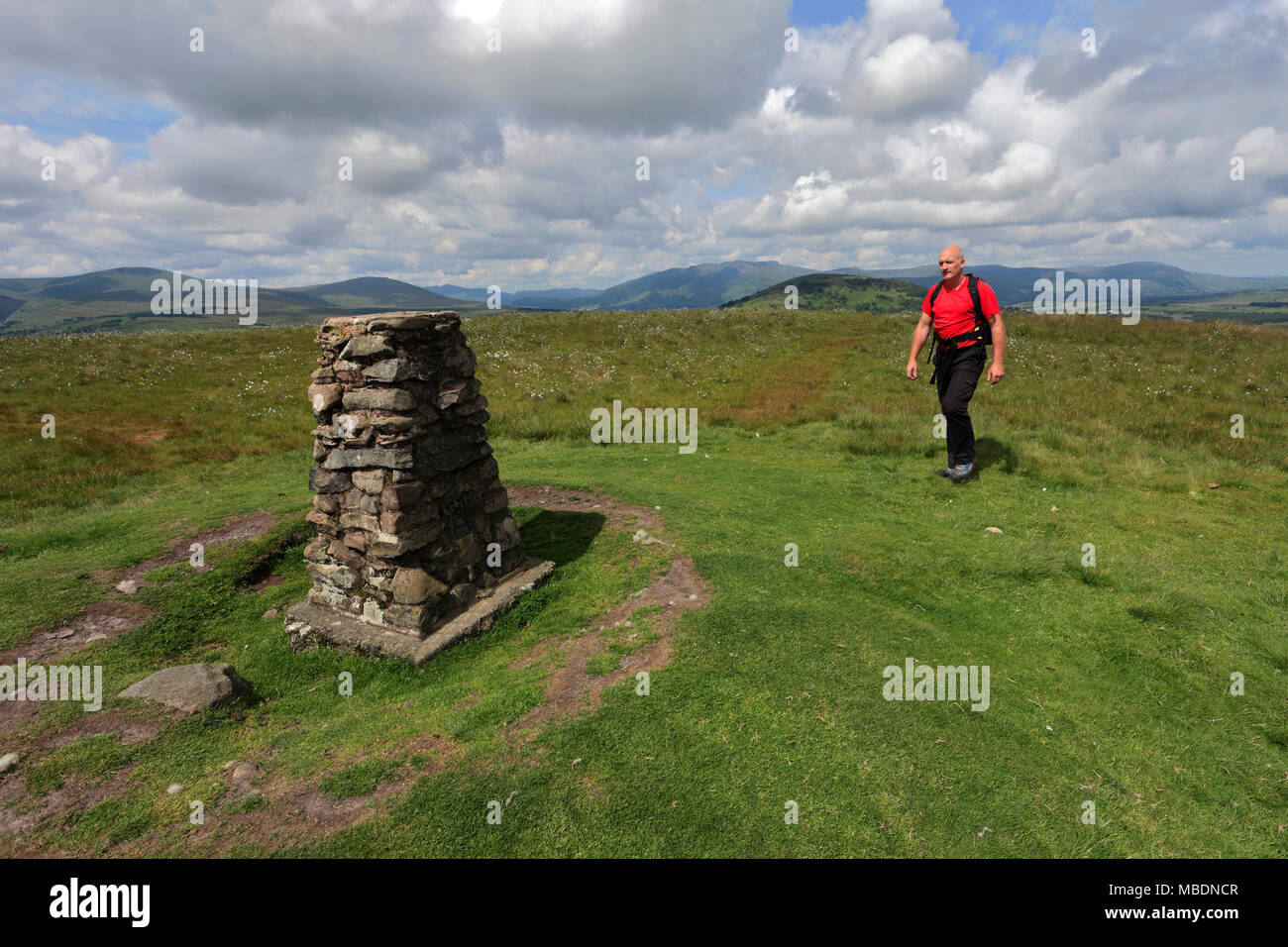 Walker at the Ordnance survey trig point, summit of Little Mell Fell ...