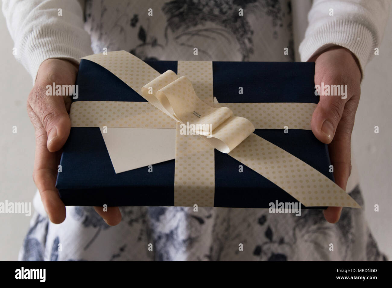 Front view of woman hands giving a gift box Stock Photo - Alamy