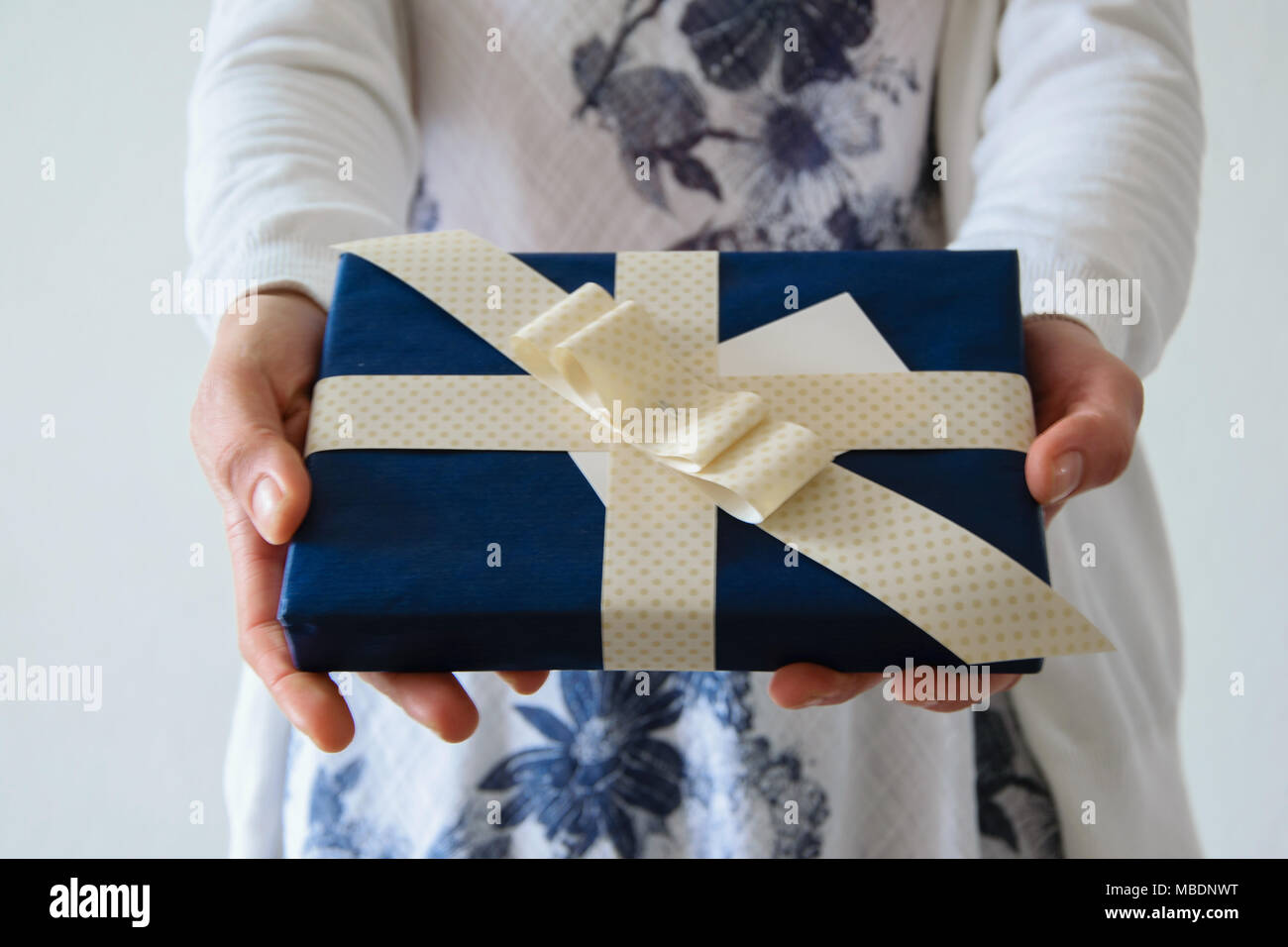 Front view of woman hands giving a gift box Stock Photo - Alamy