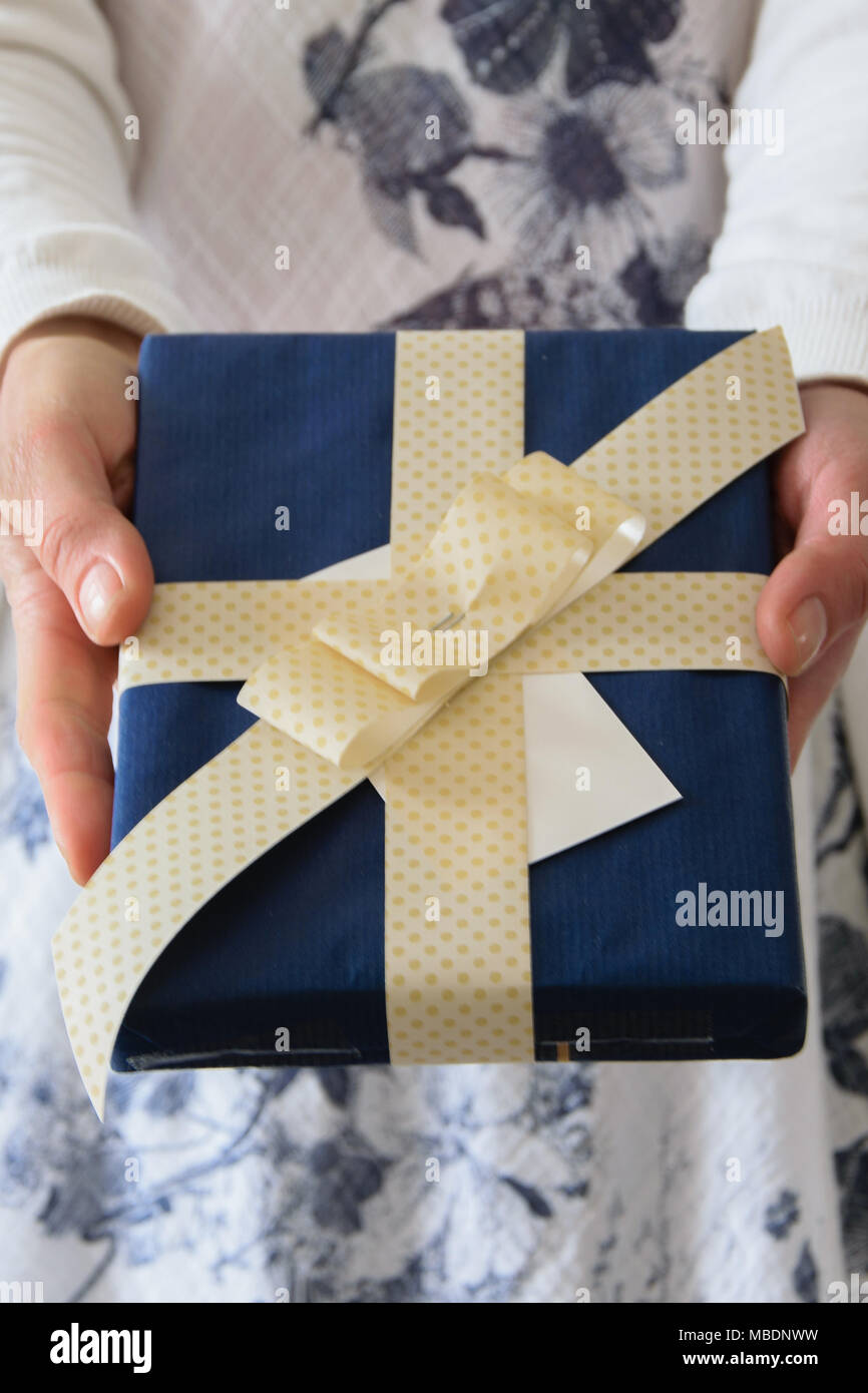 Front view of woman hands giving a gift box Stock Photo - Alamy
