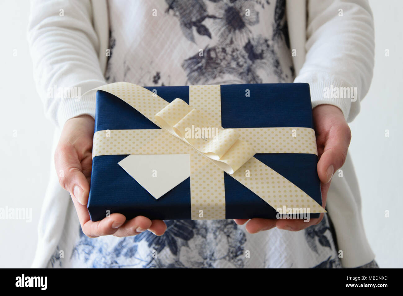 Front view of woman hands giving a gift box Stock Photo - Alamy