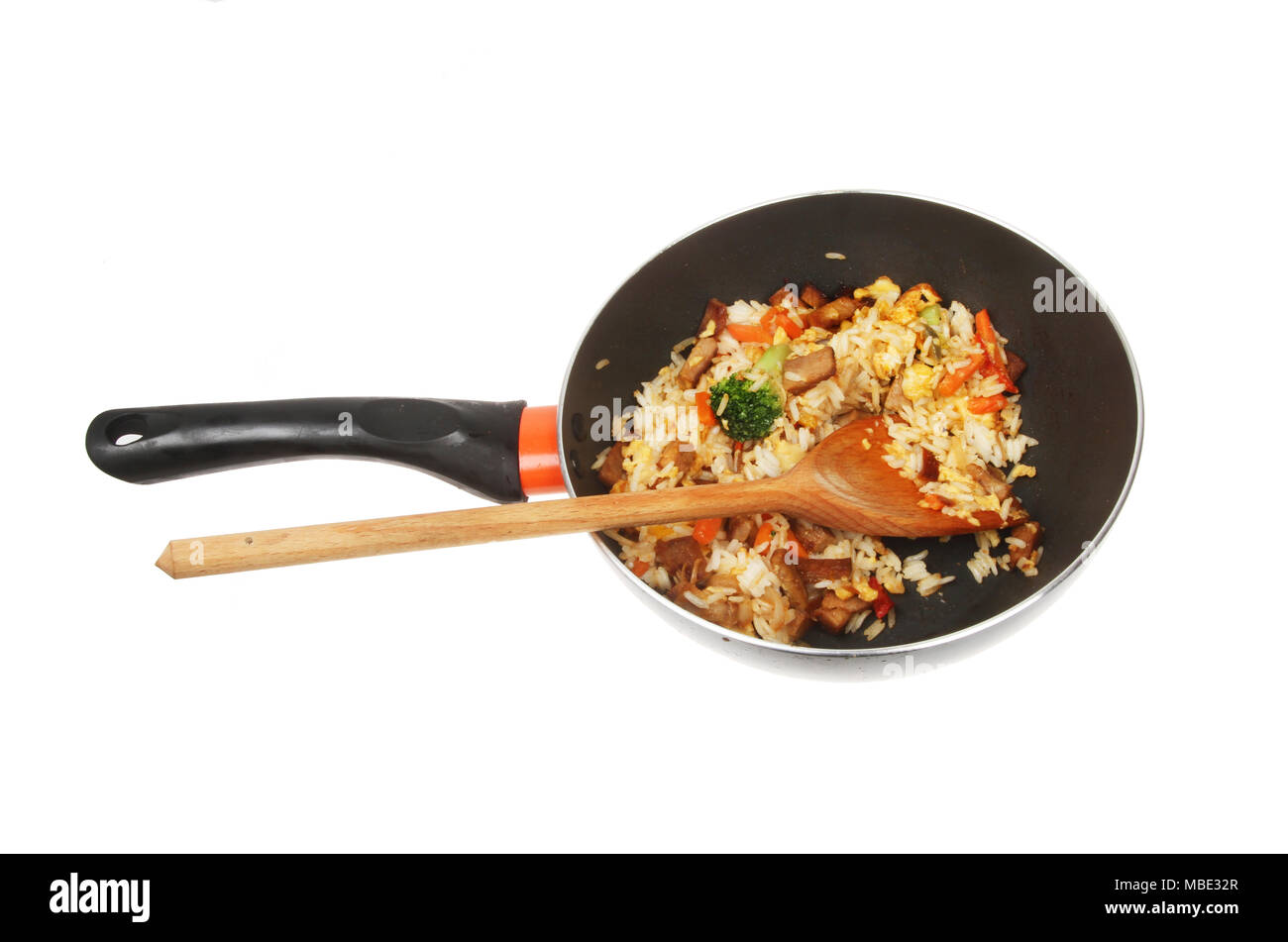 Stir fried rice with a wooden spoon in a wok isolated against white ...