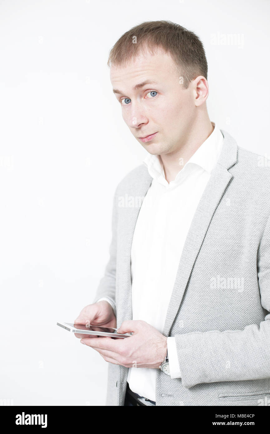 Smiling young man looking at his smart phone while text messaging on ...