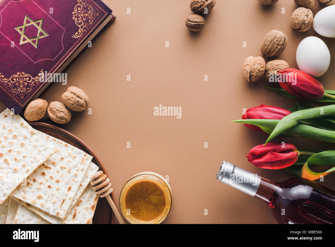 top view of traditional book with text in hebrew, wine and matza on ...