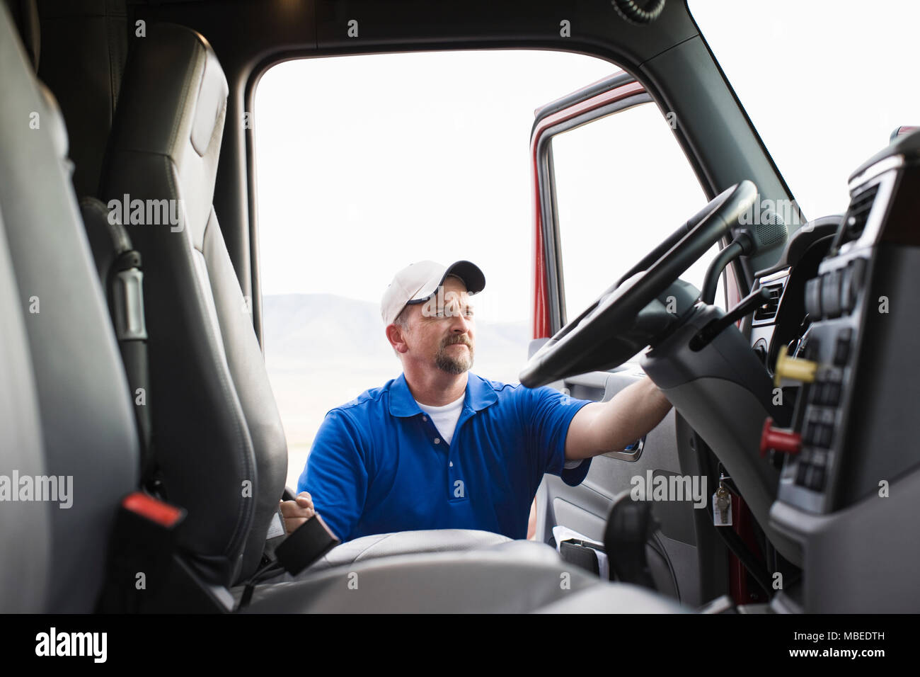 Driver getting into the cab of a commercial truck Stock Photo - Alamy