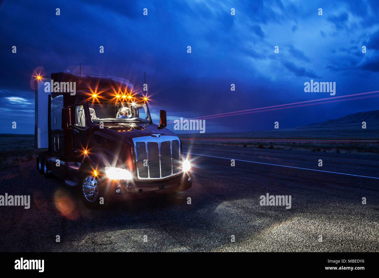 View into the cab of a commercial truck with a driver in the front seat ...