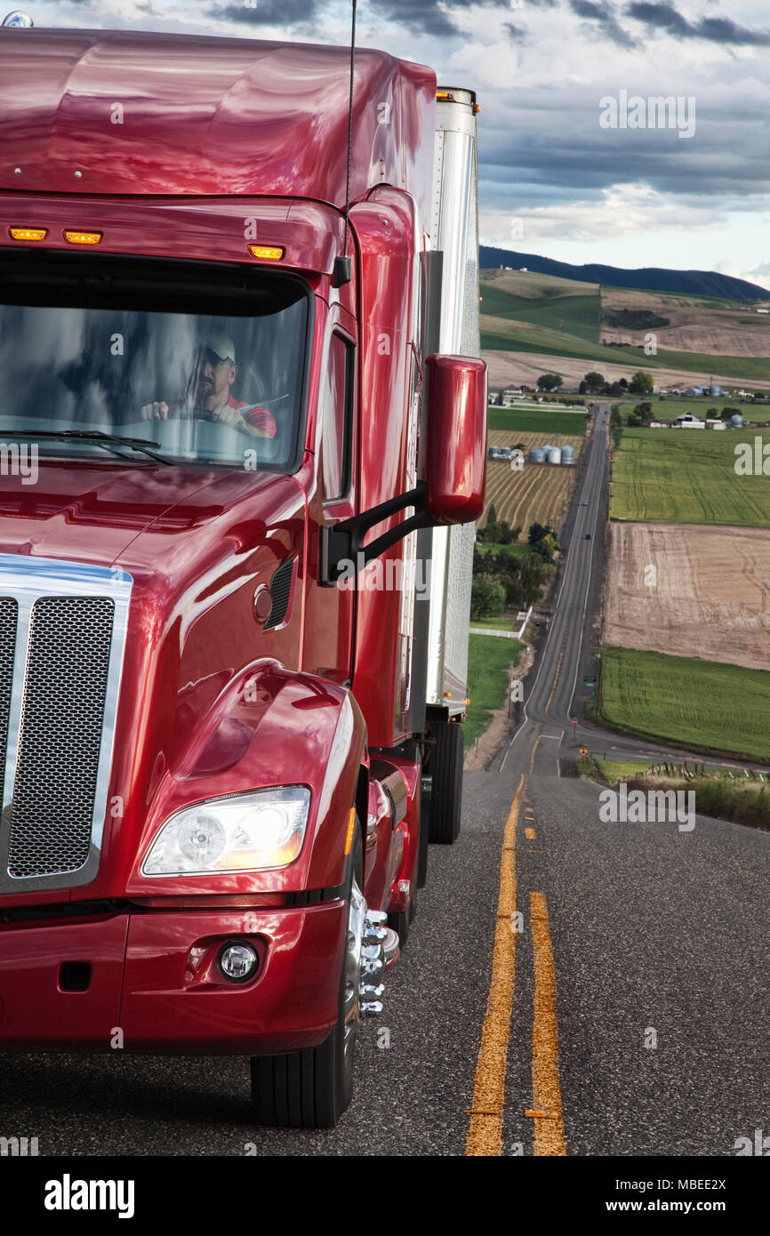 Close up view of the cab and driver of a commercial truck on the ...