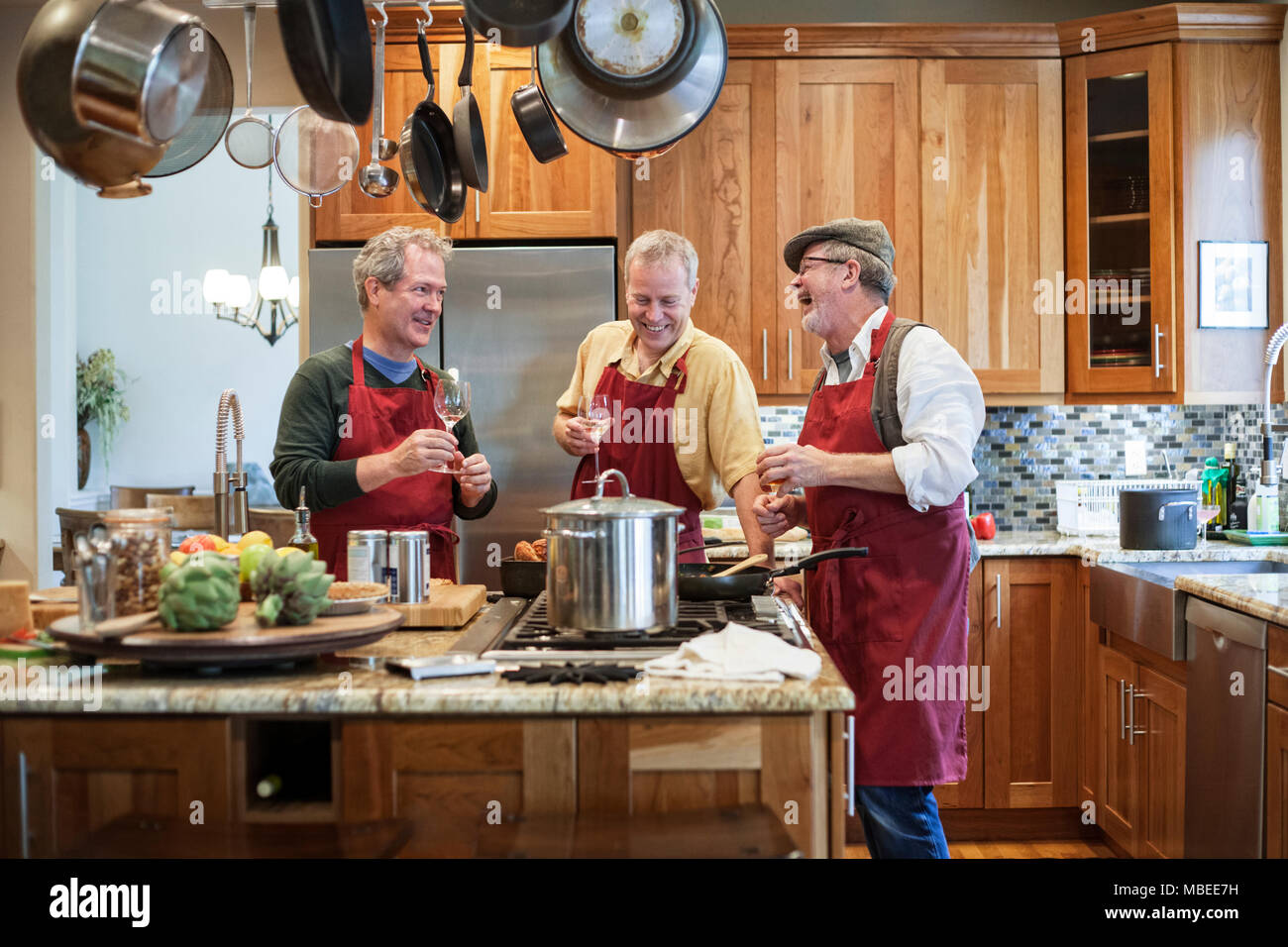 Three senior men friends cooking a meal in the kitchen Stock Photo - Alamy