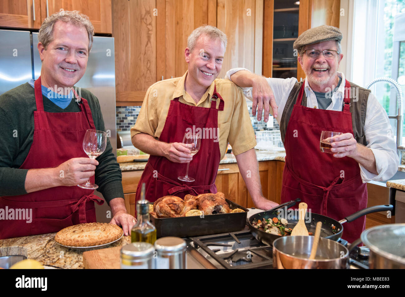 Three senior men friends cooking a meal in the kitchen Stock Photo - Alamy