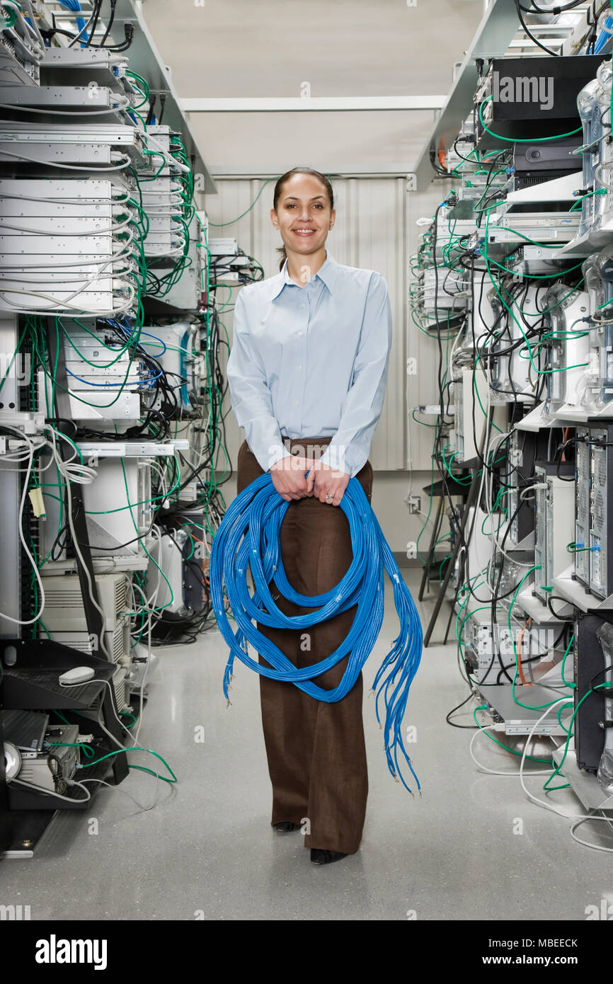 Female computer technician holding CAT 5 cables and standing in the ...