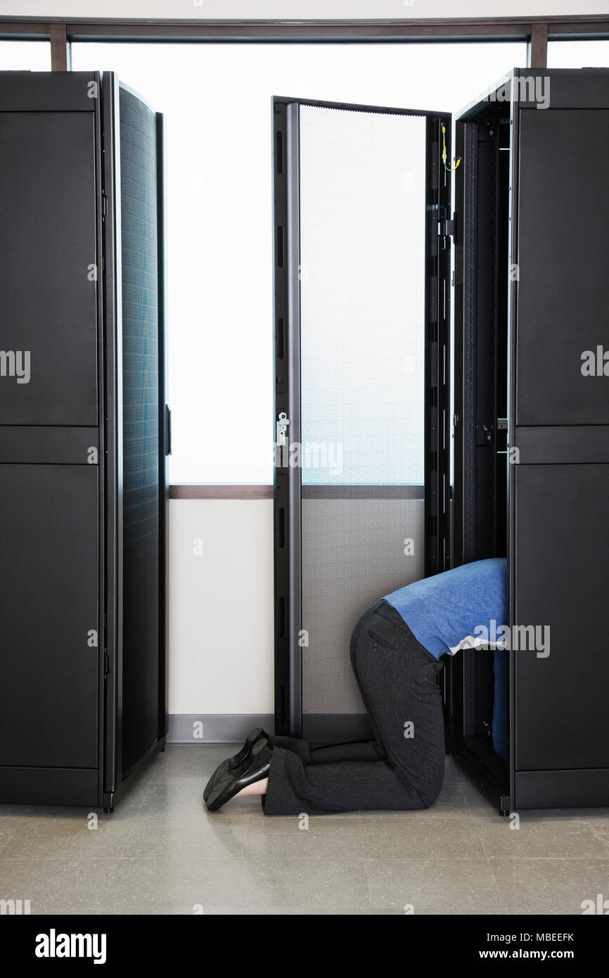 A technician workign in the rack area of a computer server farm Stock ...