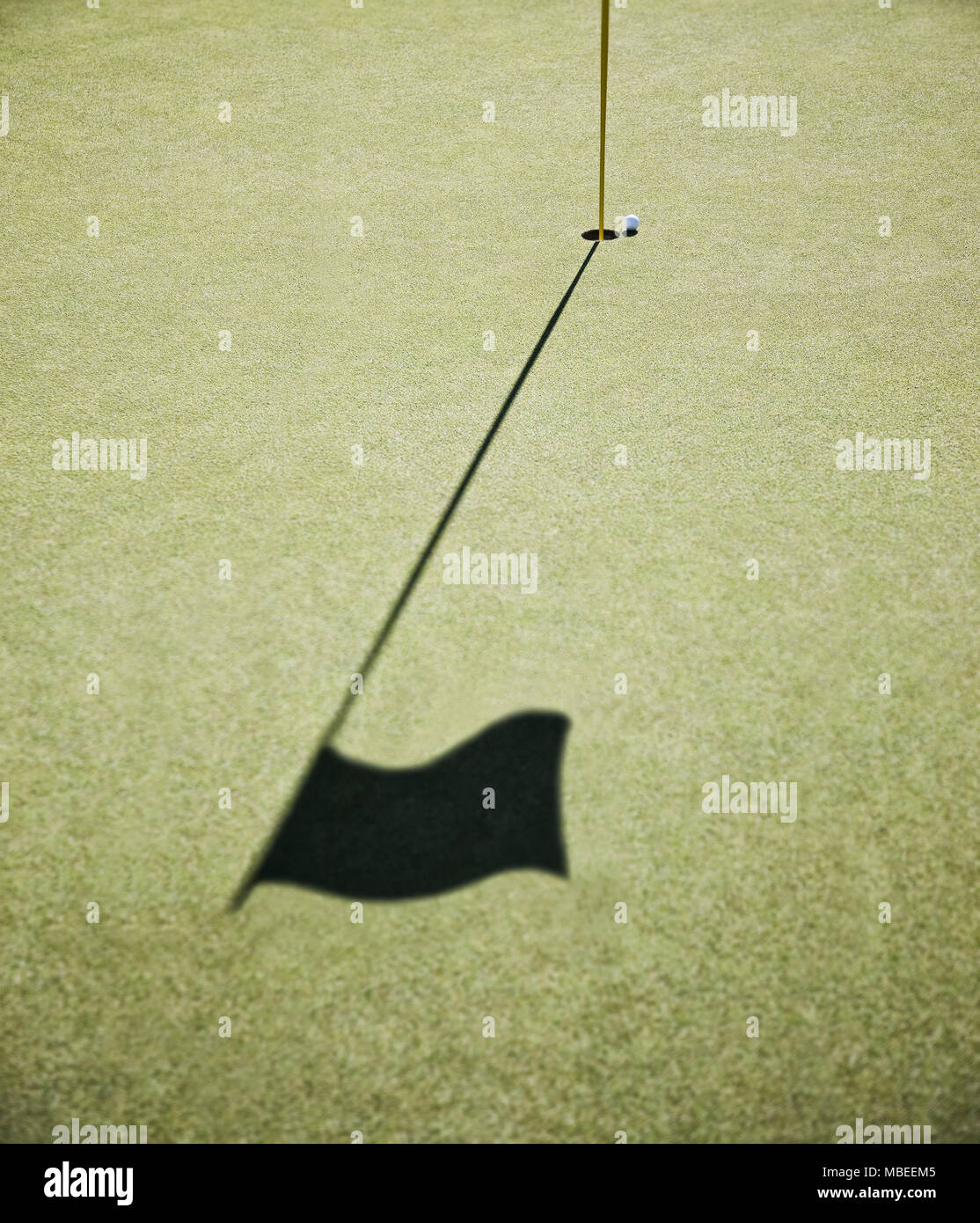 Shadow of a golf flag on the green of a golf course Stock Photo - Alamy