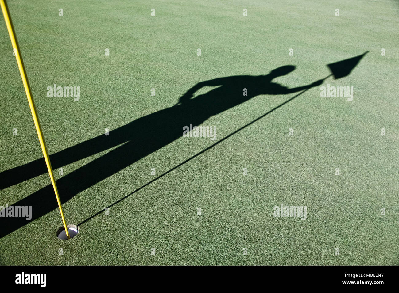 Shadow of golfers and the flag on a green of a golf course Stock Photo ...
