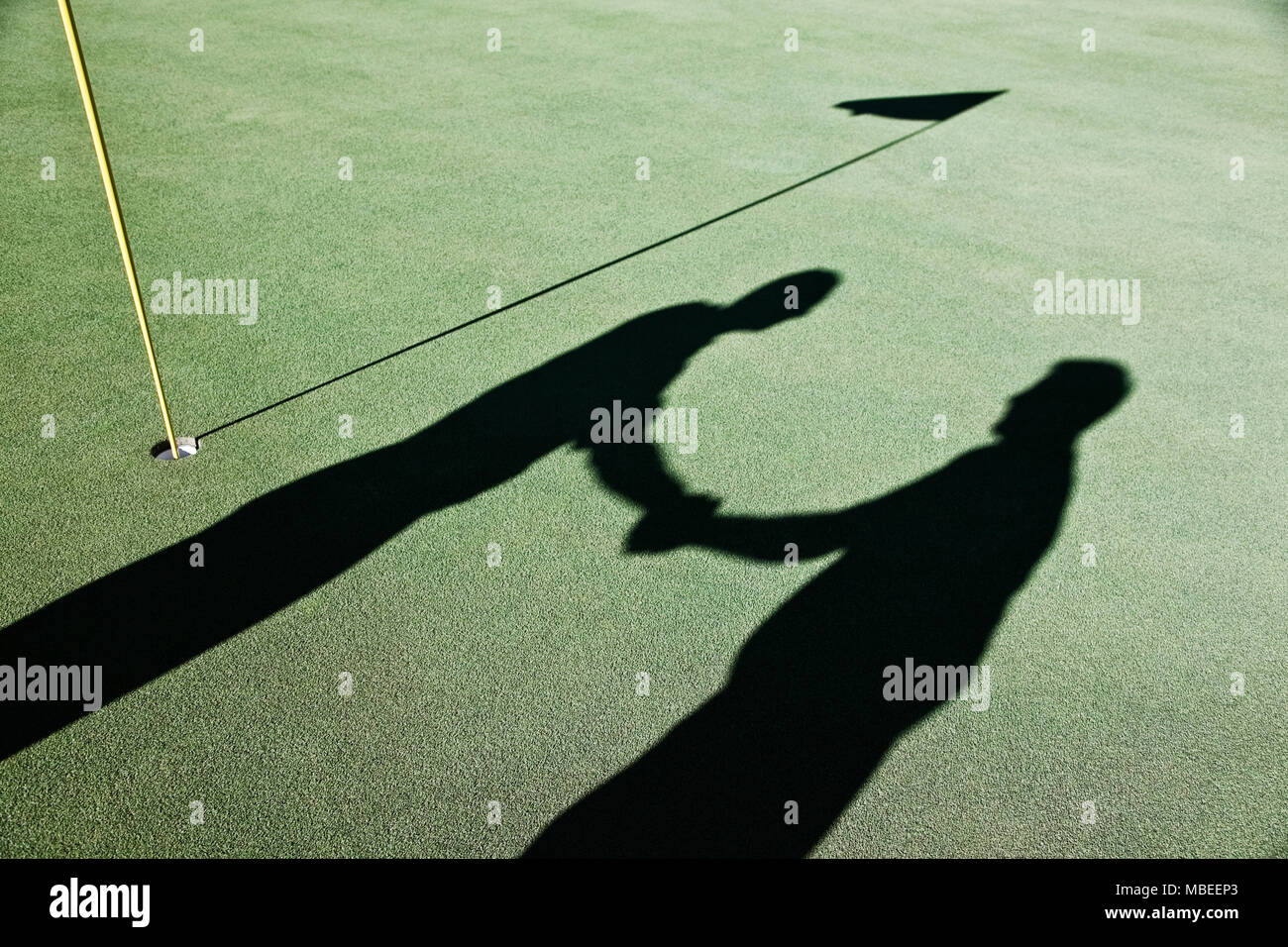 Shadow of golfers and the flag on a green of a golf course Stock Photo ...
