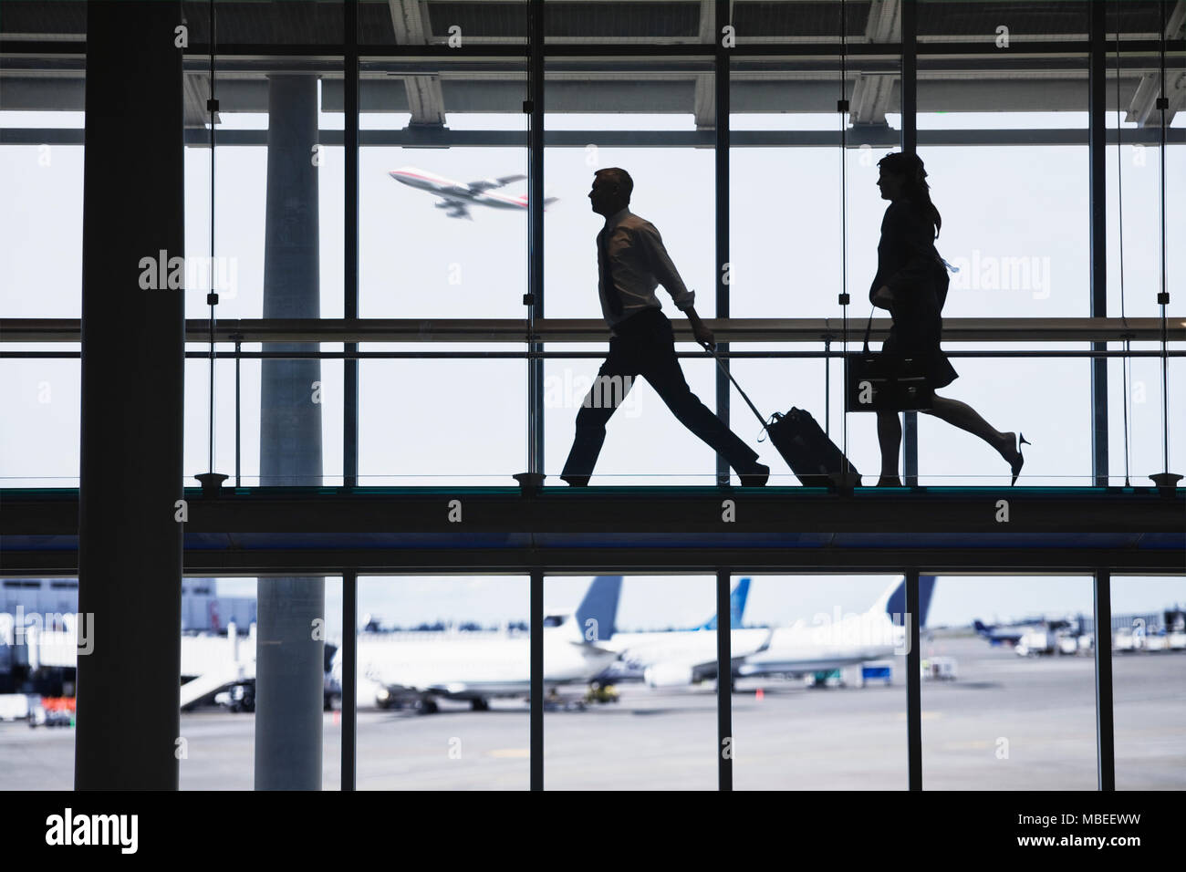Businessman and business woman running to catch an airplane on an ...