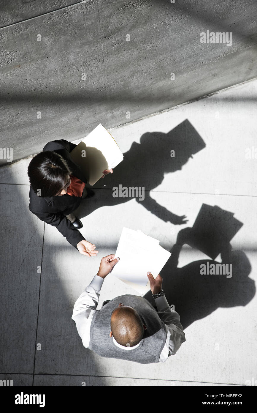 View looking down on a businesswoman and businessman talking in an ...