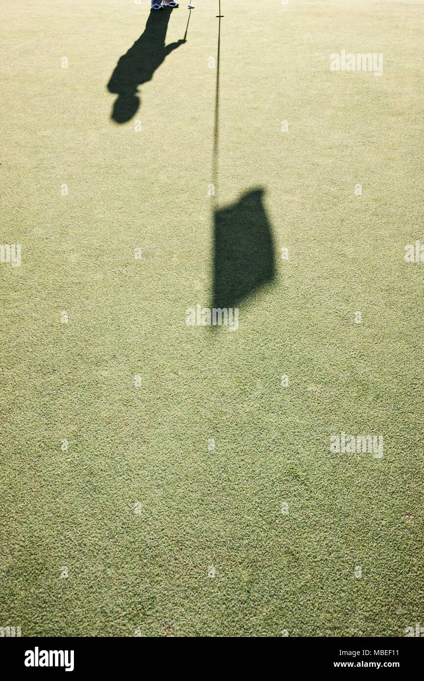 Shadow of a golfer and a flag on a golf green Stock Photo - Alamy