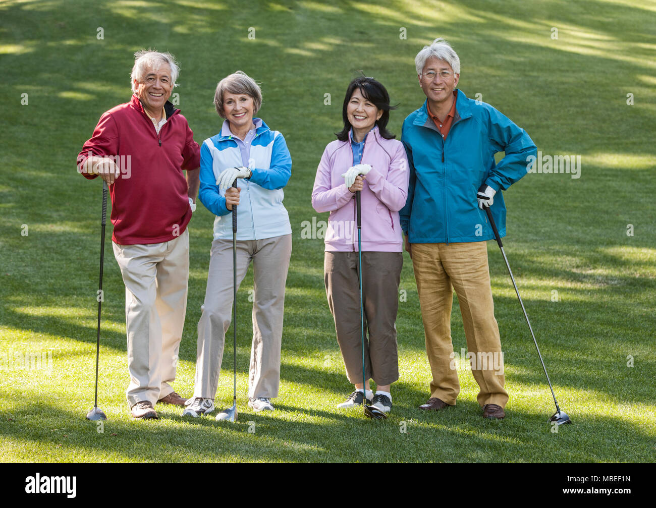 Two young senior golfing couples on the course and ready to play Stock ...