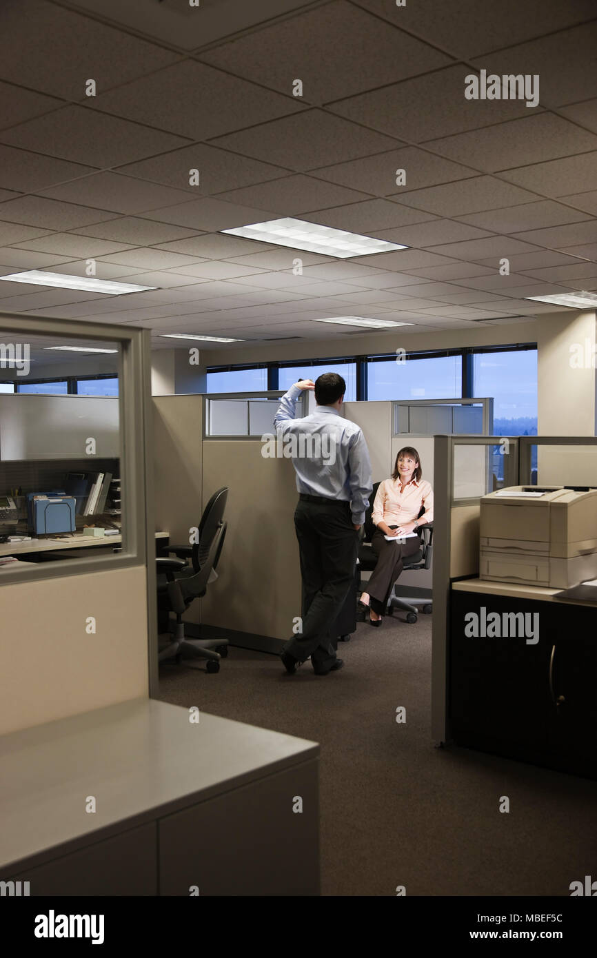 Two young business people working into the evening in a cubicle office set up Stock Photo - Alamy