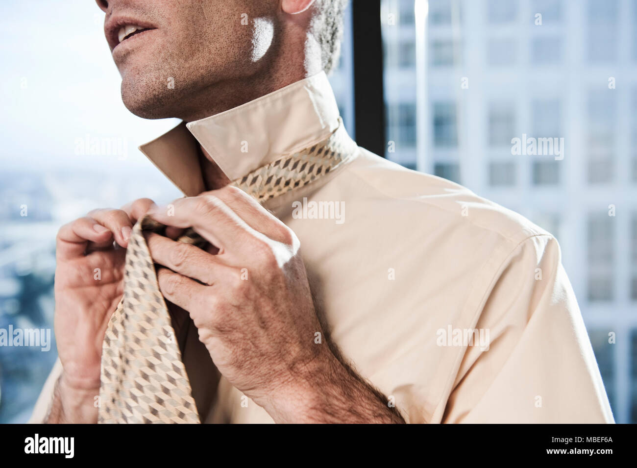 Businessman putting on a shirt and tie before work Stock Photo - Alamy