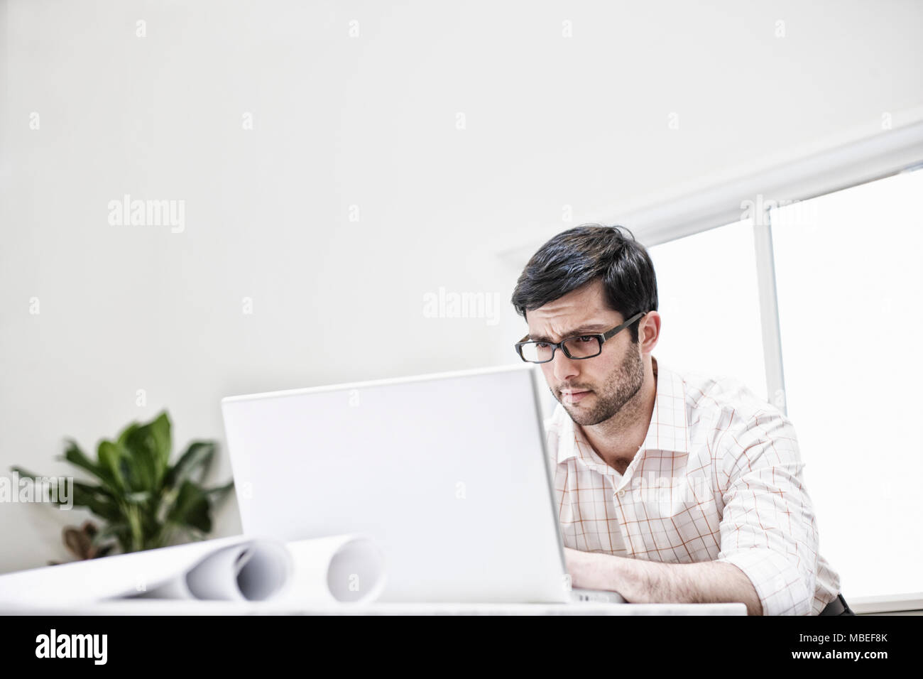 Hispanic man working in an architect's office Stock Photo - Alamy