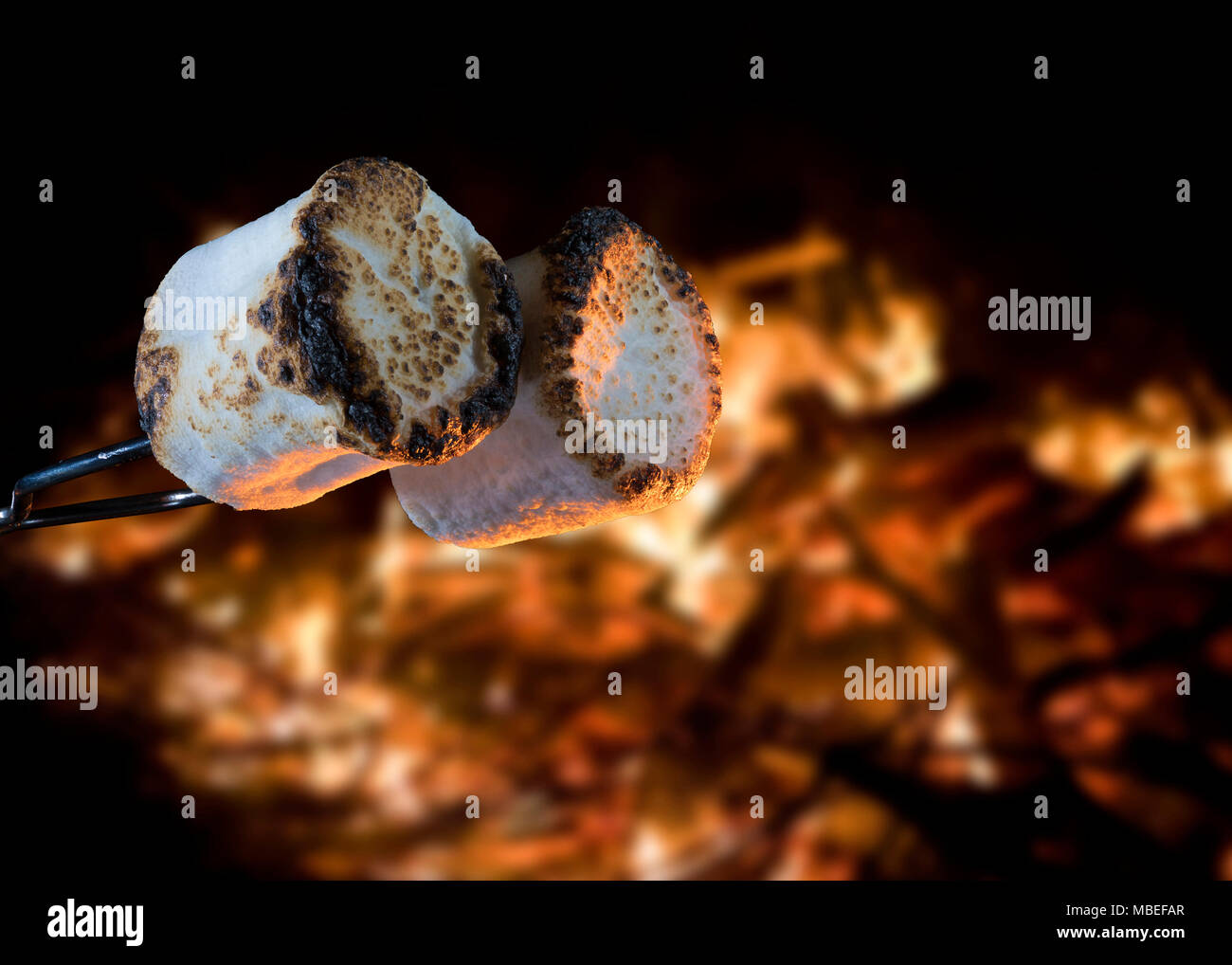 Two marshmallows being roasted over a campfire to make smores Stock ...