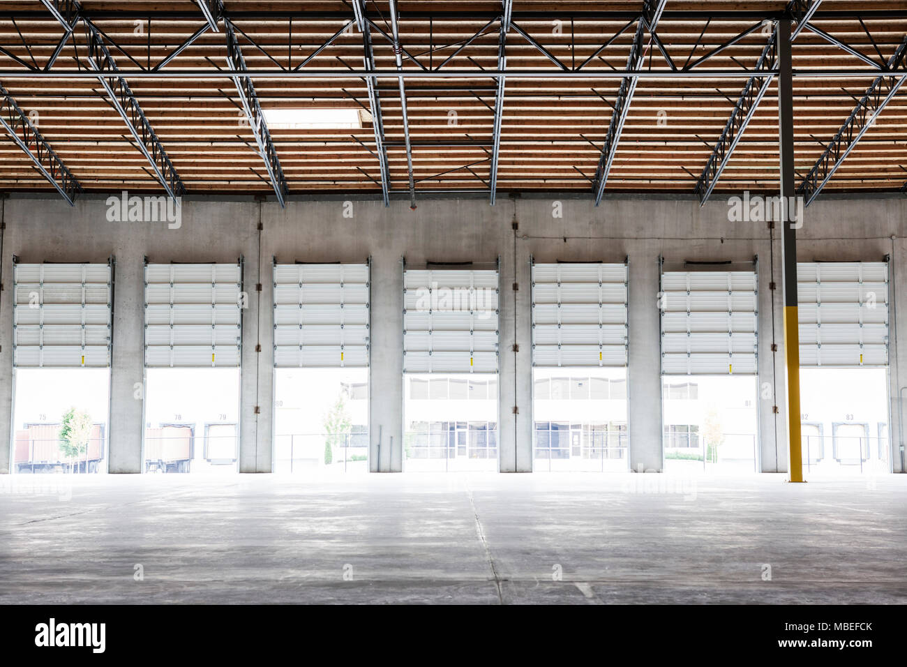 Wide angle interior view of largeempty warehouse and loading dock doors ...