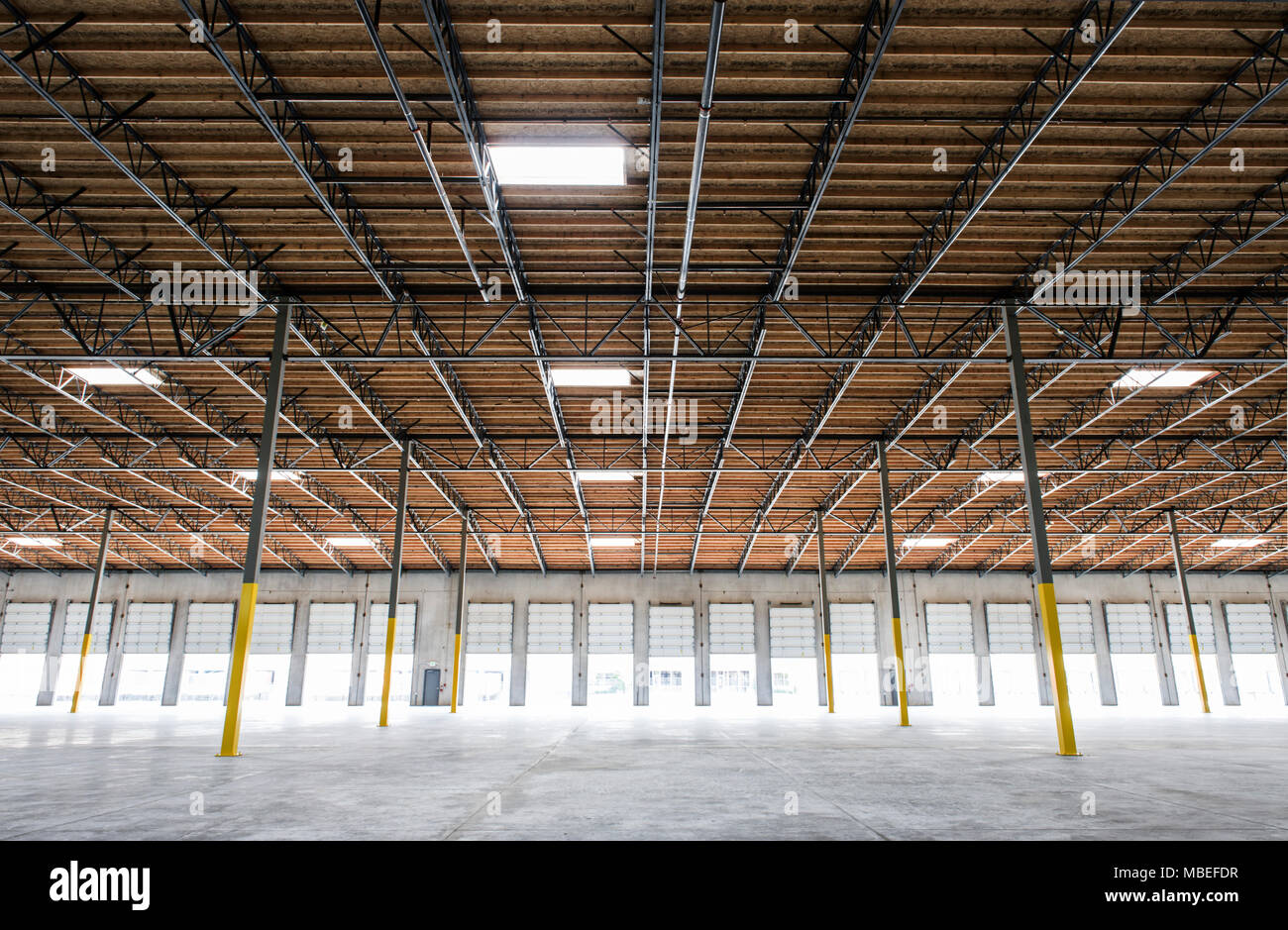 Wide angle interior view of largeempty warehouse and loading dock doors ...