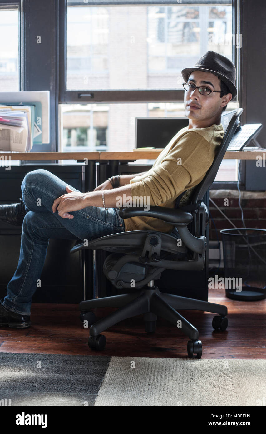 Hispanic male at his office workstation in a creative office Stock ...