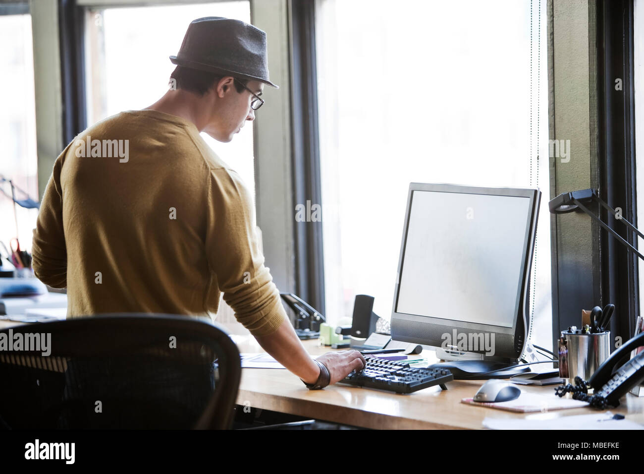 Hispanic male at his office workstation in a creative office Stock ...