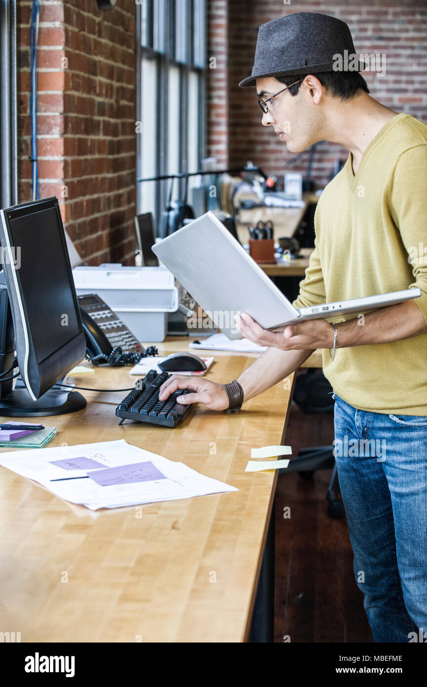 Hispanic male at his office workstation in a creative office Stock ...