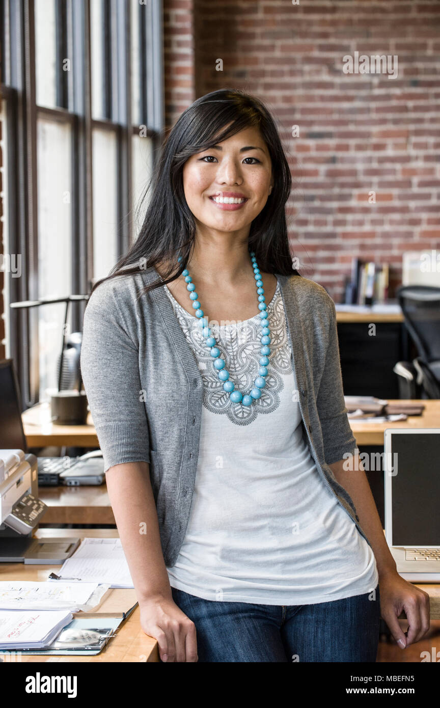 Asian woman at her creative office work station Stock Photo - Alamy