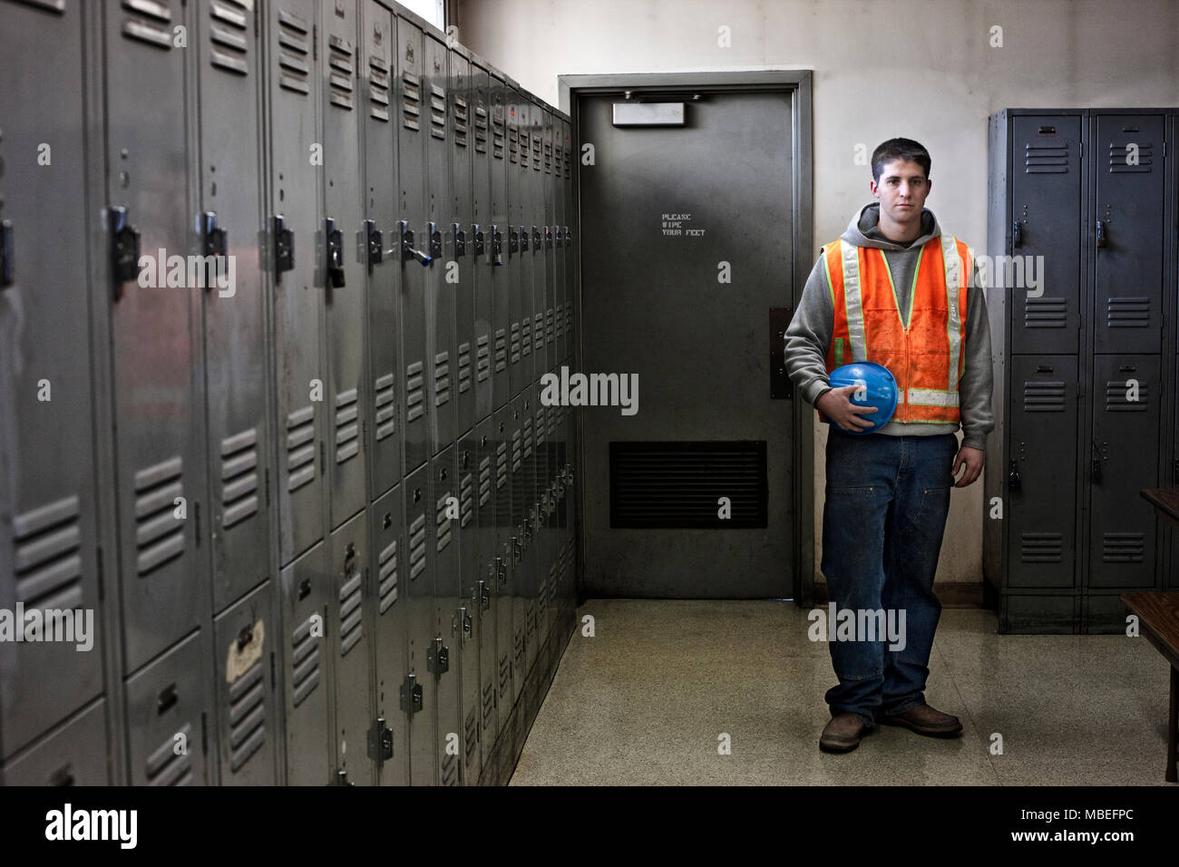 View of a young caucasian factory worker wearing a safety vest and ...