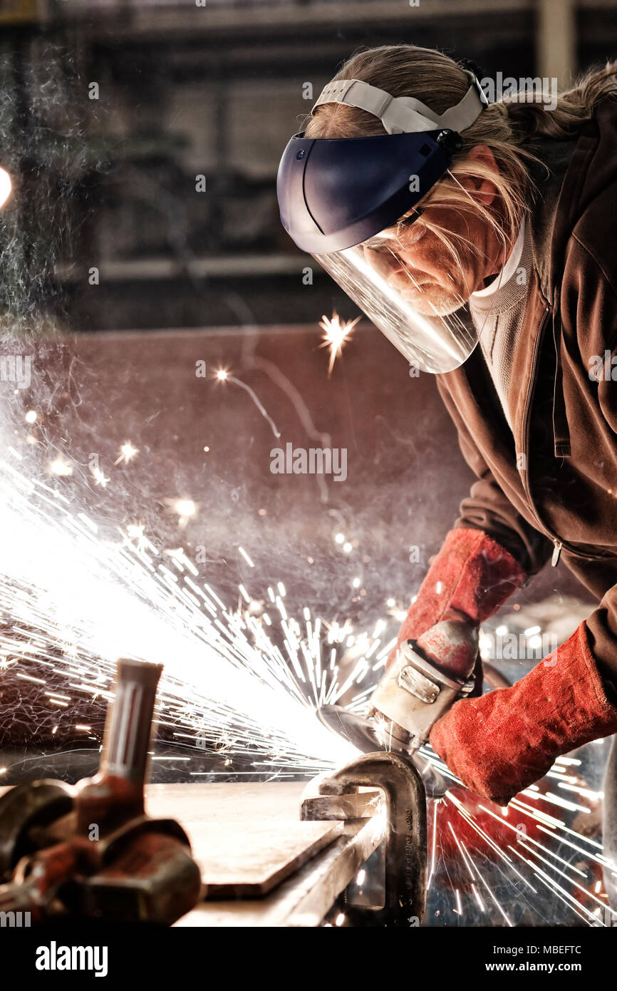 Factory worker grinding a steel edge in a sheet metal factory Stock ...