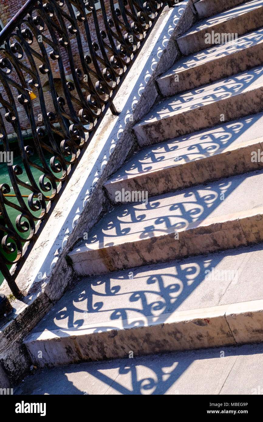a set of stone stairs with ornate railings and shadow Stock Photo - Alamy