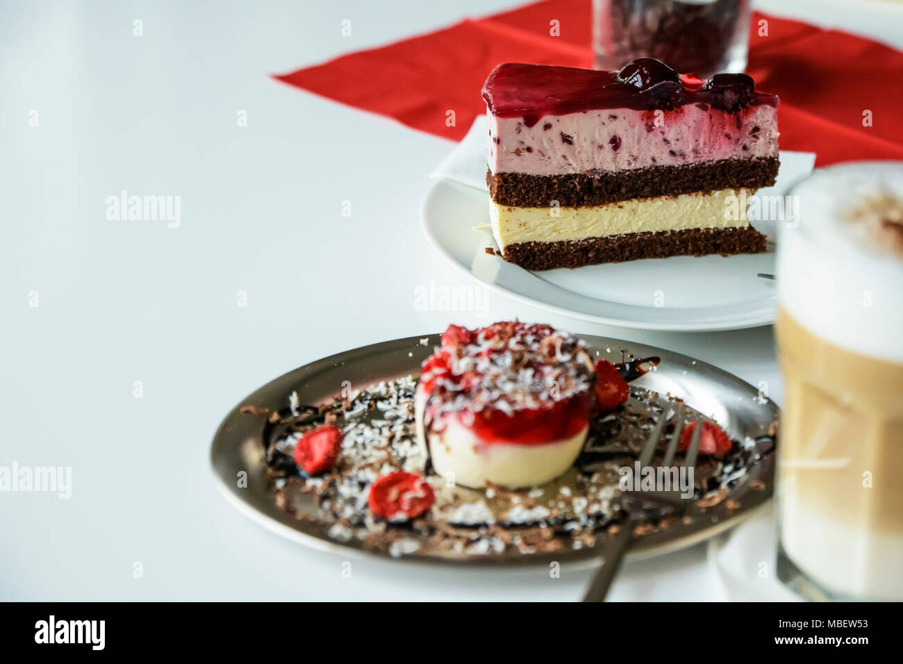 Delicious red white strawberry and a piece of cake on a white table ...