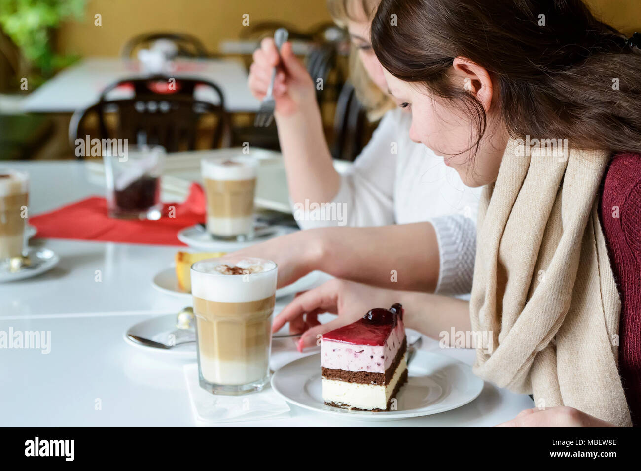 Two friends communicate with food, drink coffee and eat cake Stock ...