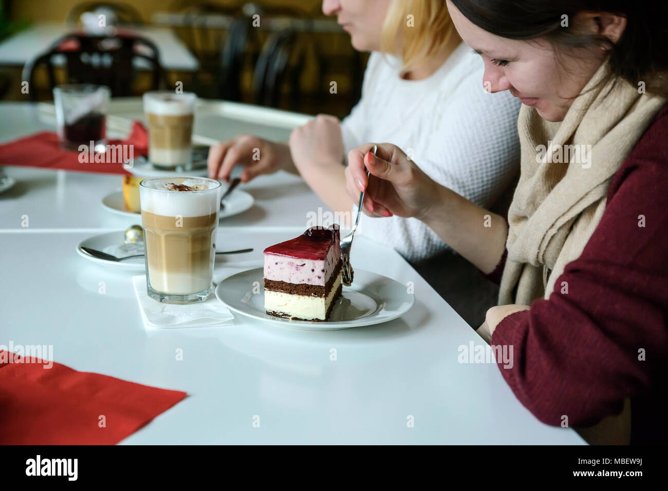Two friends communicate with food, drink coffee and eat cake Stock ...