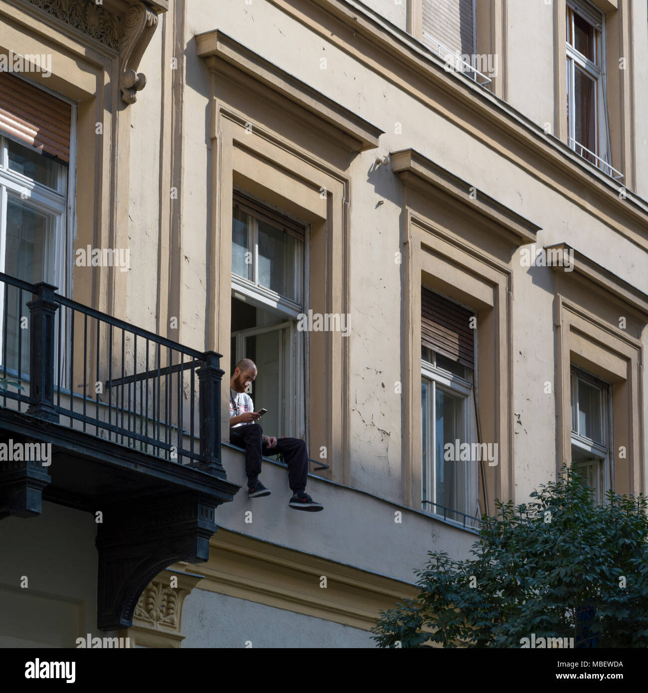 Man sitting on window ledge hi-res stock photography and images - Alamy