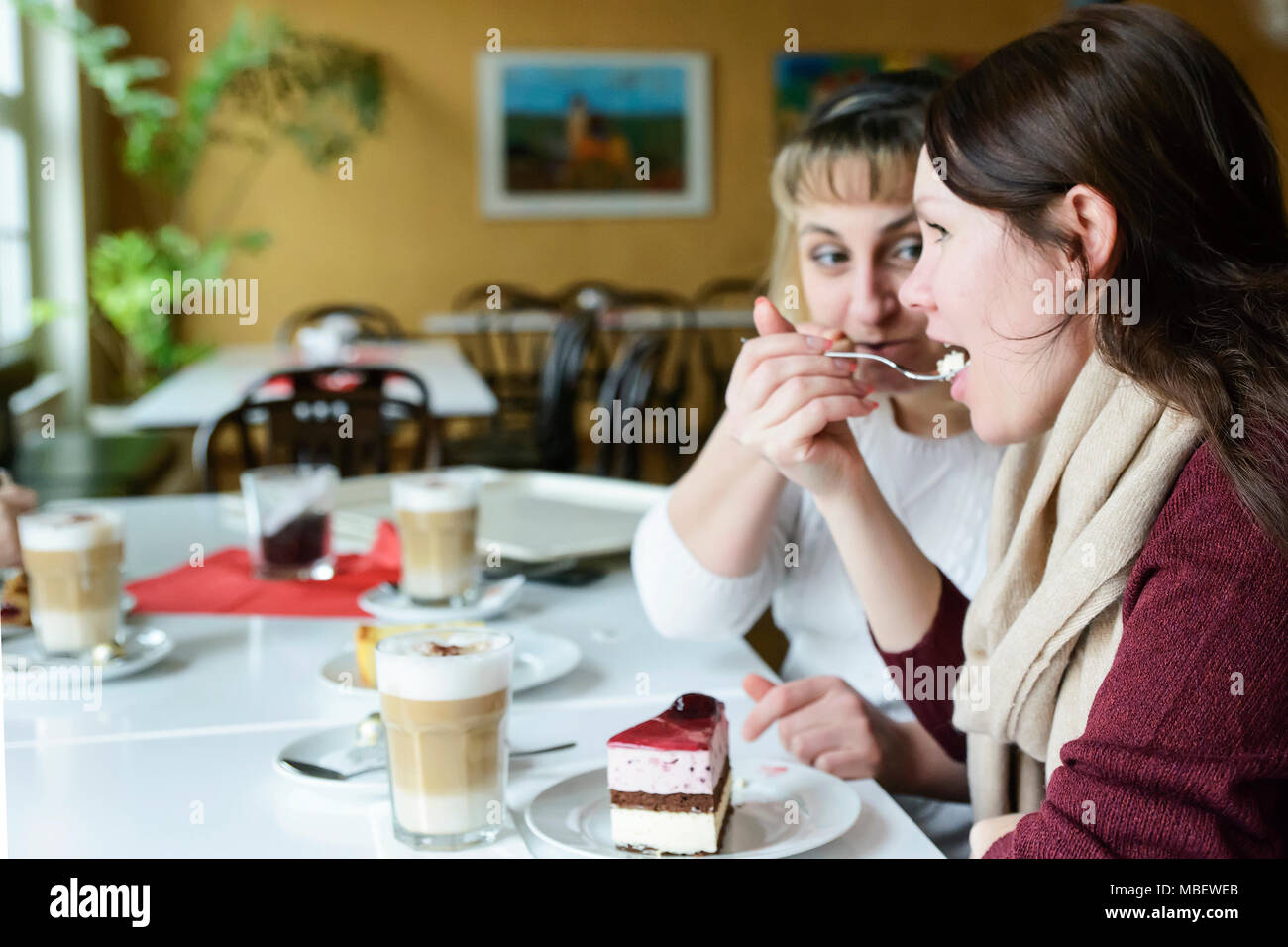 Two friends communicate with food, drink coffee and eat cake Stock ...