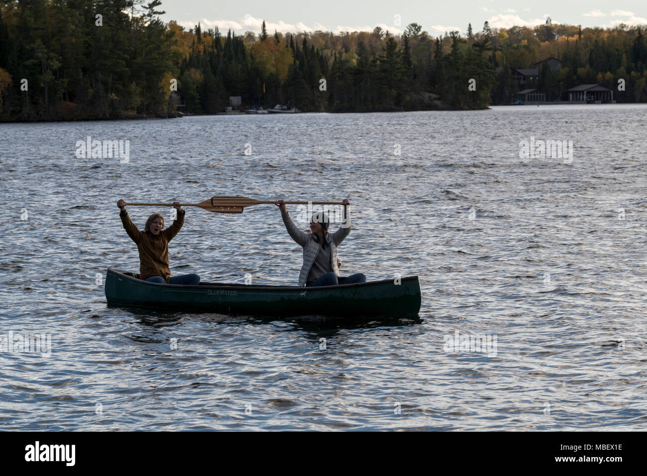 Two young friends rowing boat in a lake, Kenora, Lake of the Woods ...
