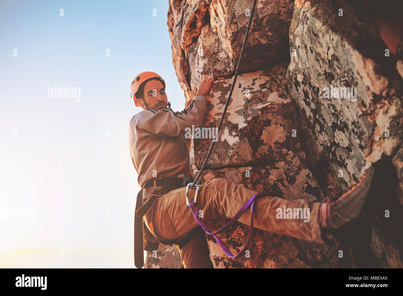 Focused male rock climber hanging from rock Stock Photo - Alamy