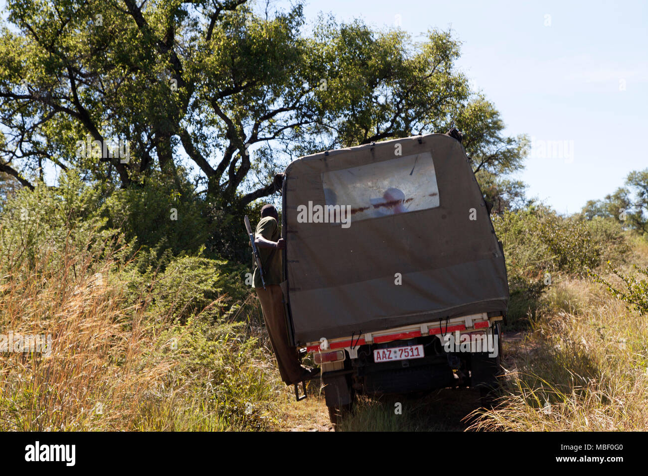 An armed guide stands on the back of an off-road vehicle in Matobo ...