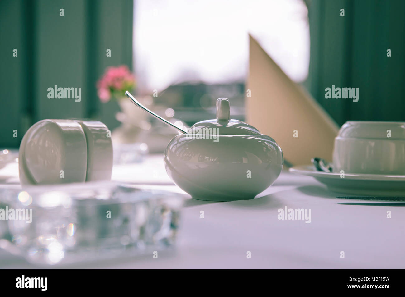 Morning table setting for breakfast from white tableware by the window ...