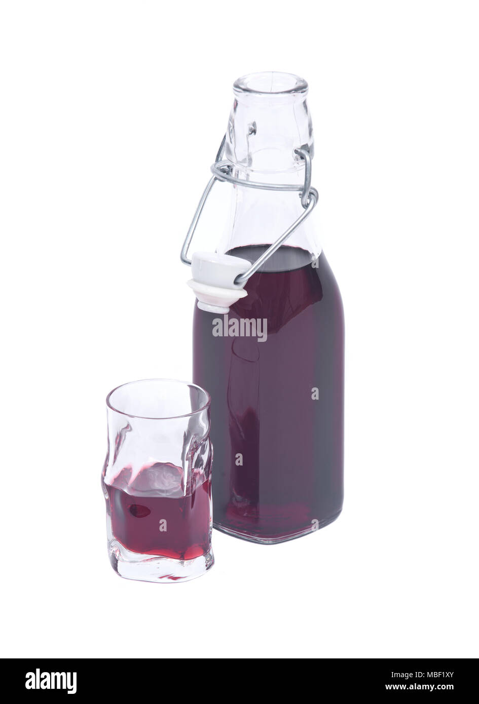 Homemade raspberry liqueur in clear glass bottle with swing top and ...